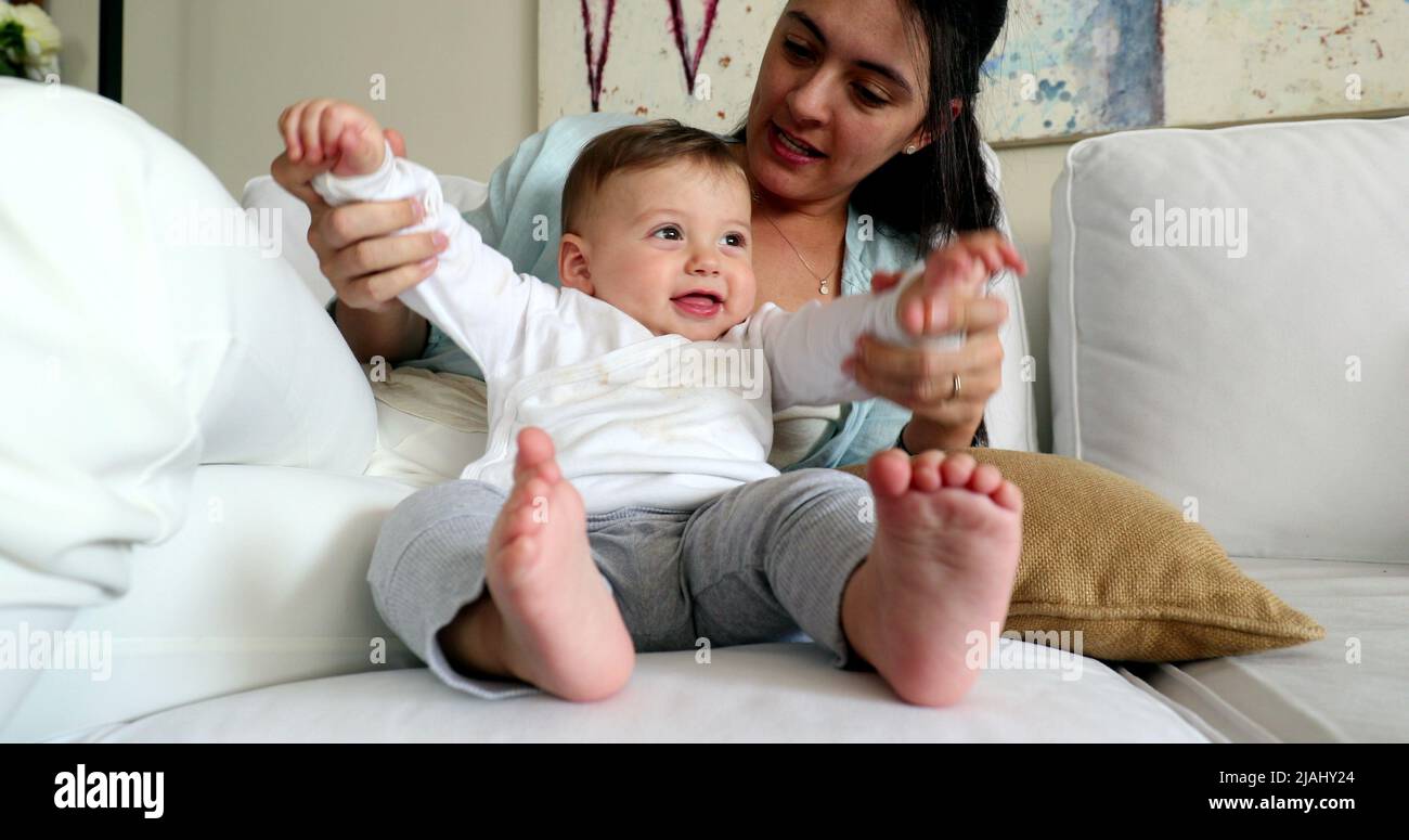 Authentic mother and baby son playing together, playful mom and toddler ...