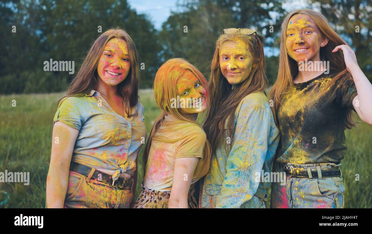 Cheerful girls posing smeared in multi-colored powder Stock Photo - Alamy