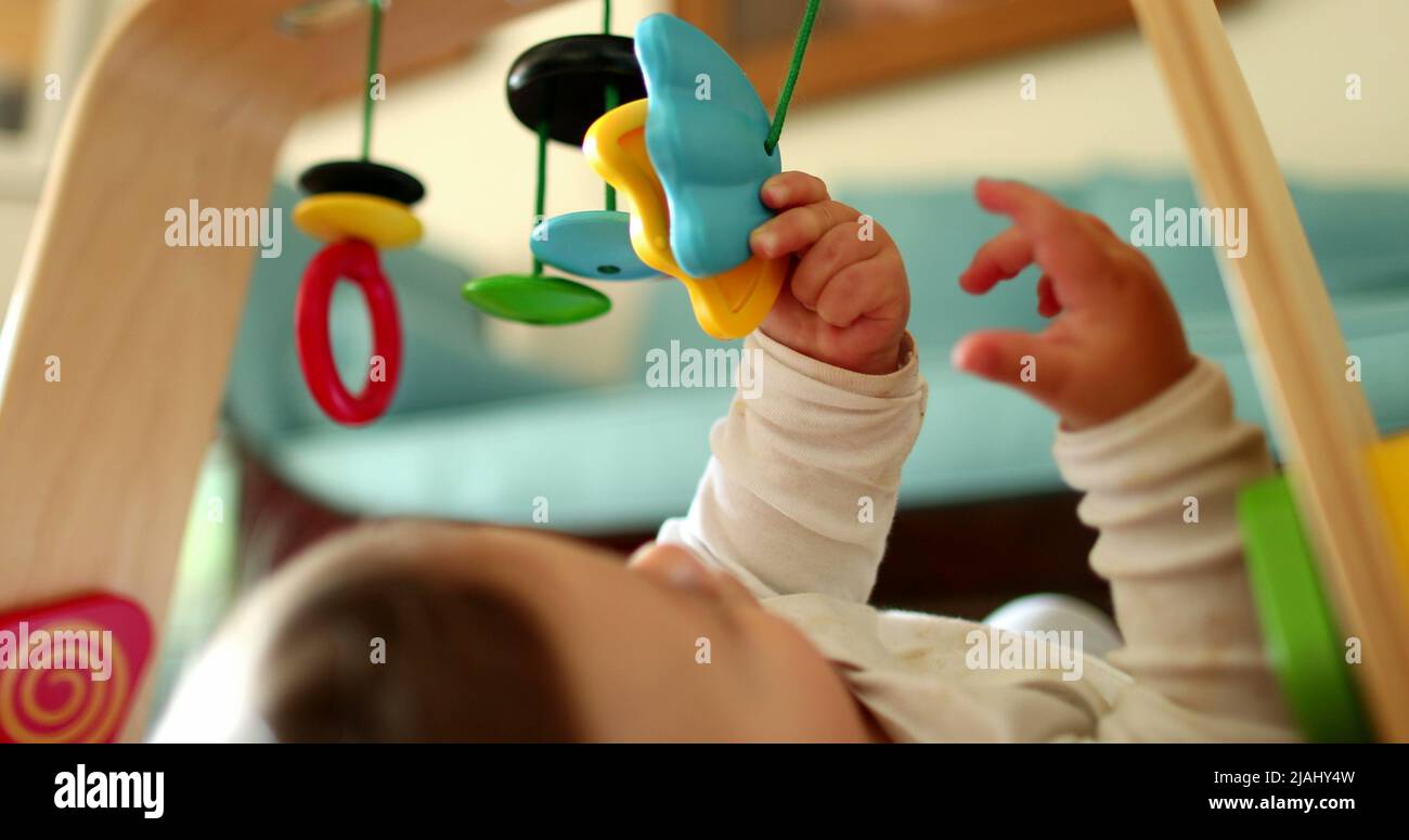 Baby hands holding play toy, close-up infant plays with child ...
