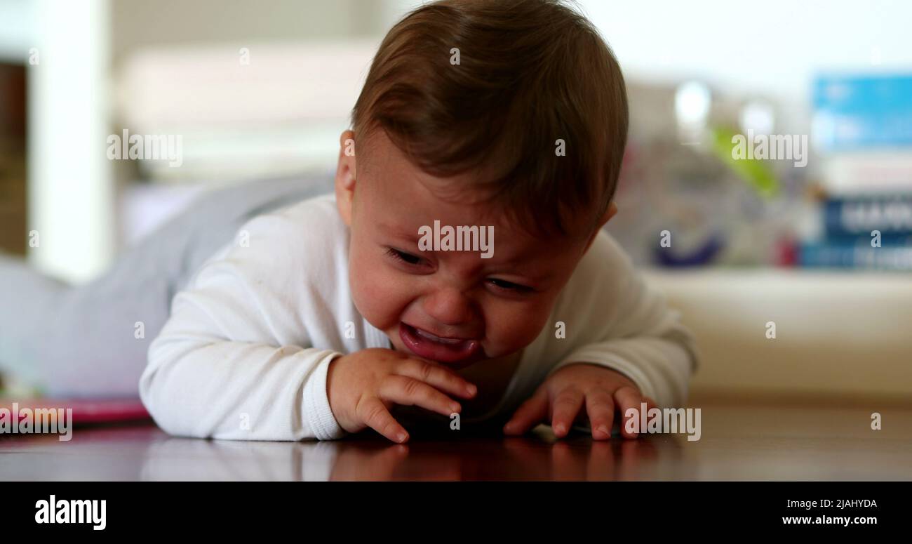 Baby infant lying on floor starts to cry. Upset angry toddler boy Stock ...