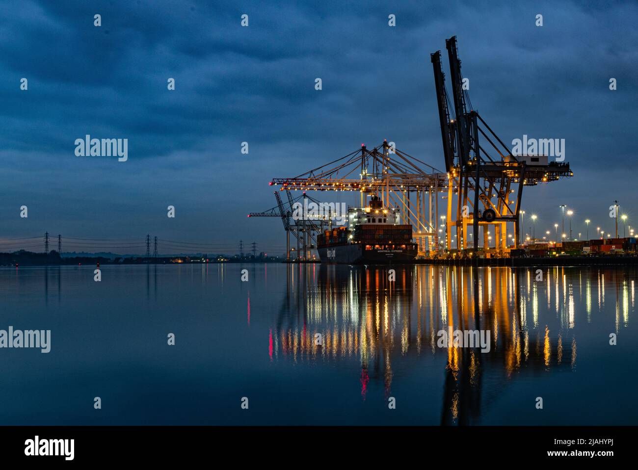 Cargo ship loading at Southampton container terminal at night viewed ...