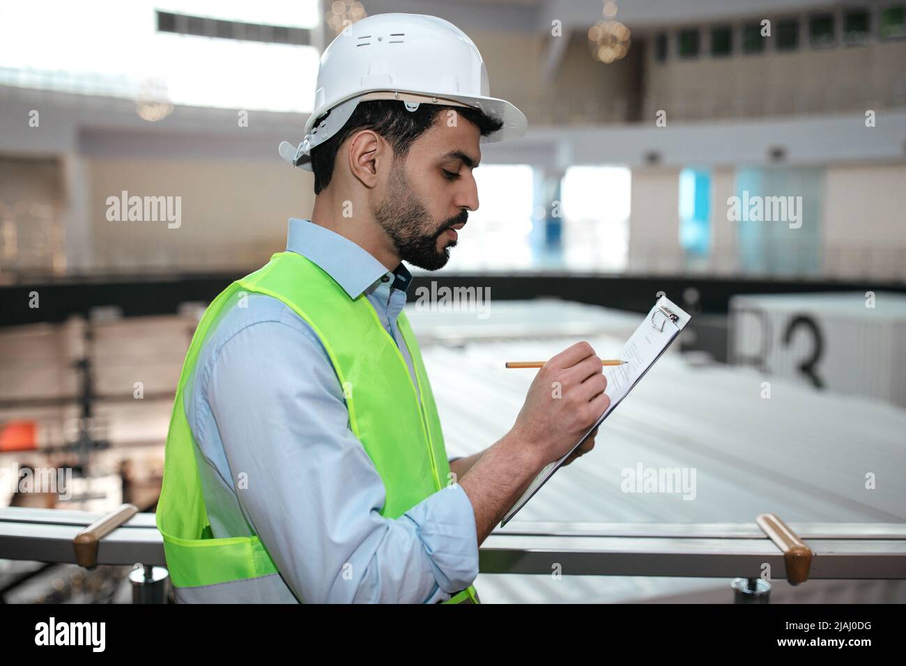 Thoughtful millennial islamic man engineer in protective uniform and ...