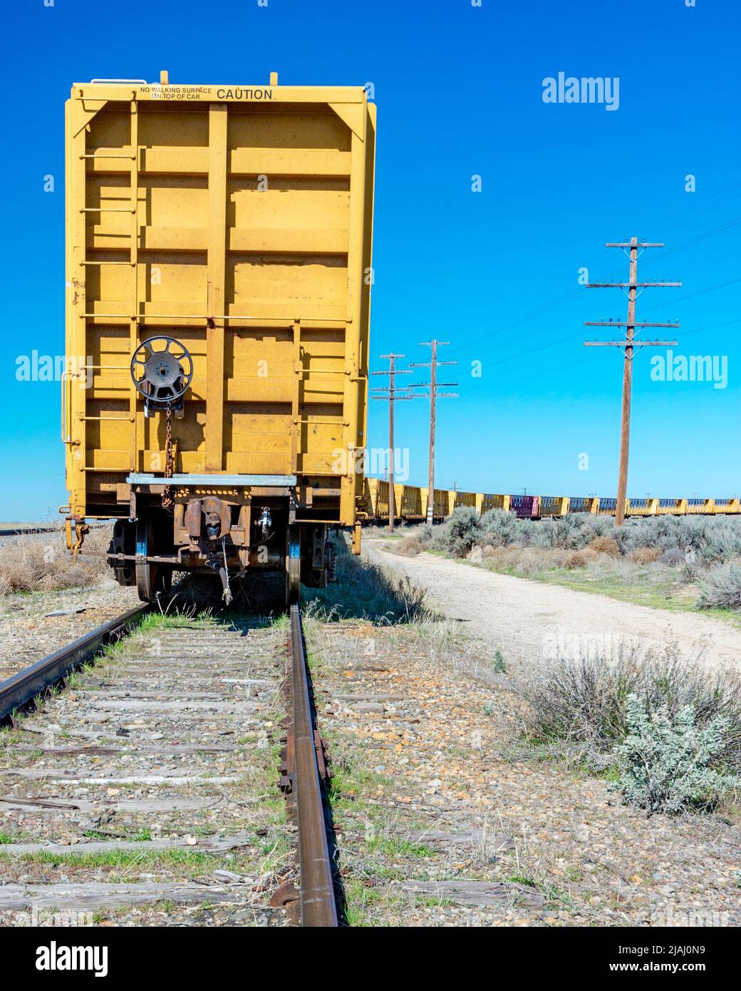 Desert train tracs with yellow cars on them Stock Photo - Alamy