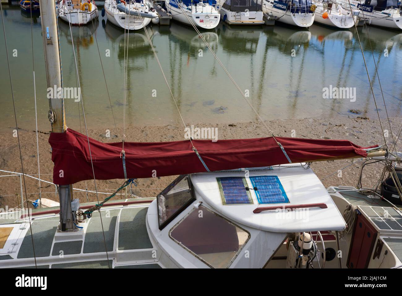 Yacht mast and boom with sail cover, boom cover and yacht deck close up ...