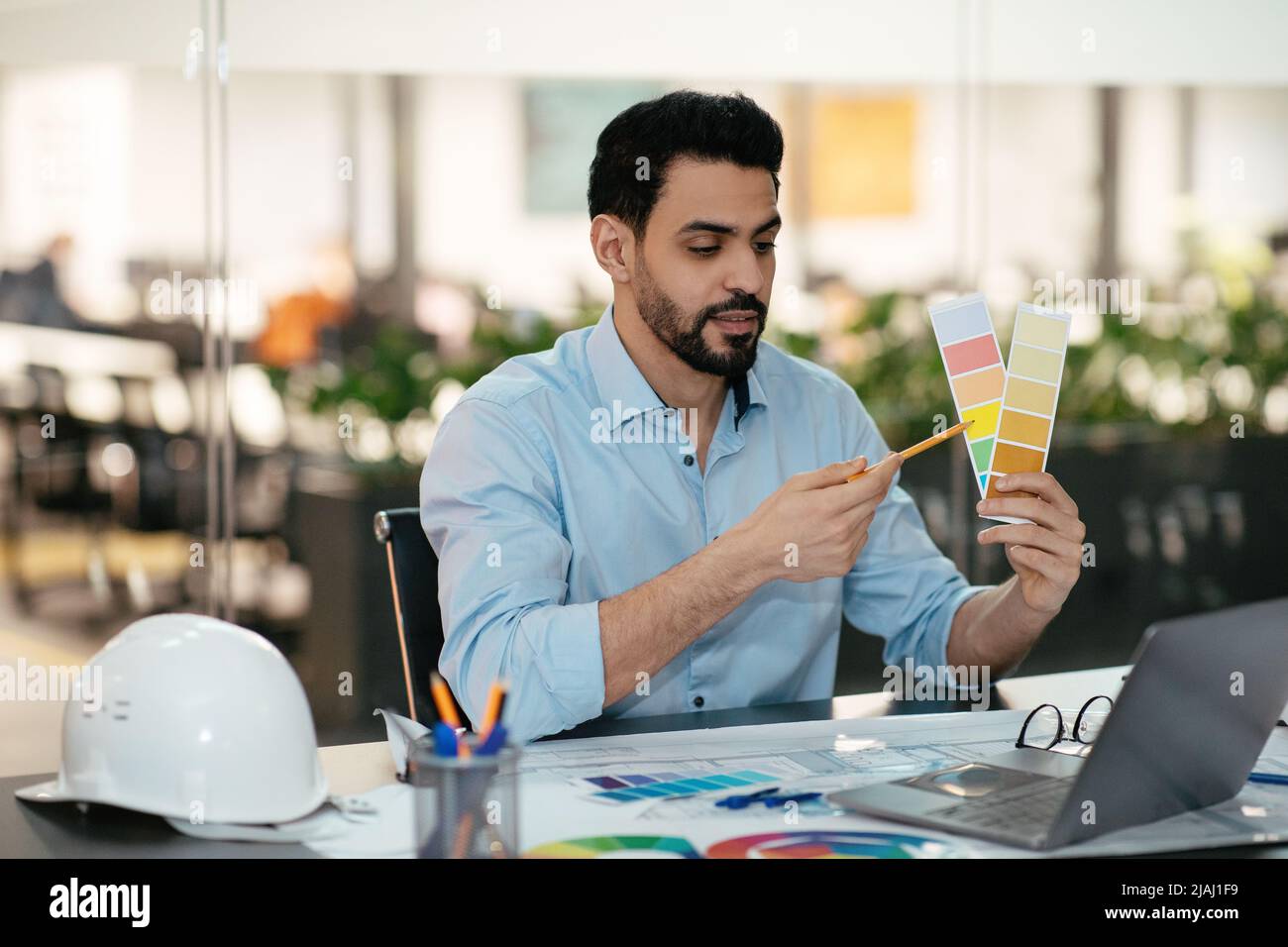 Serious young islamic male engineer designer with beard shows color ...