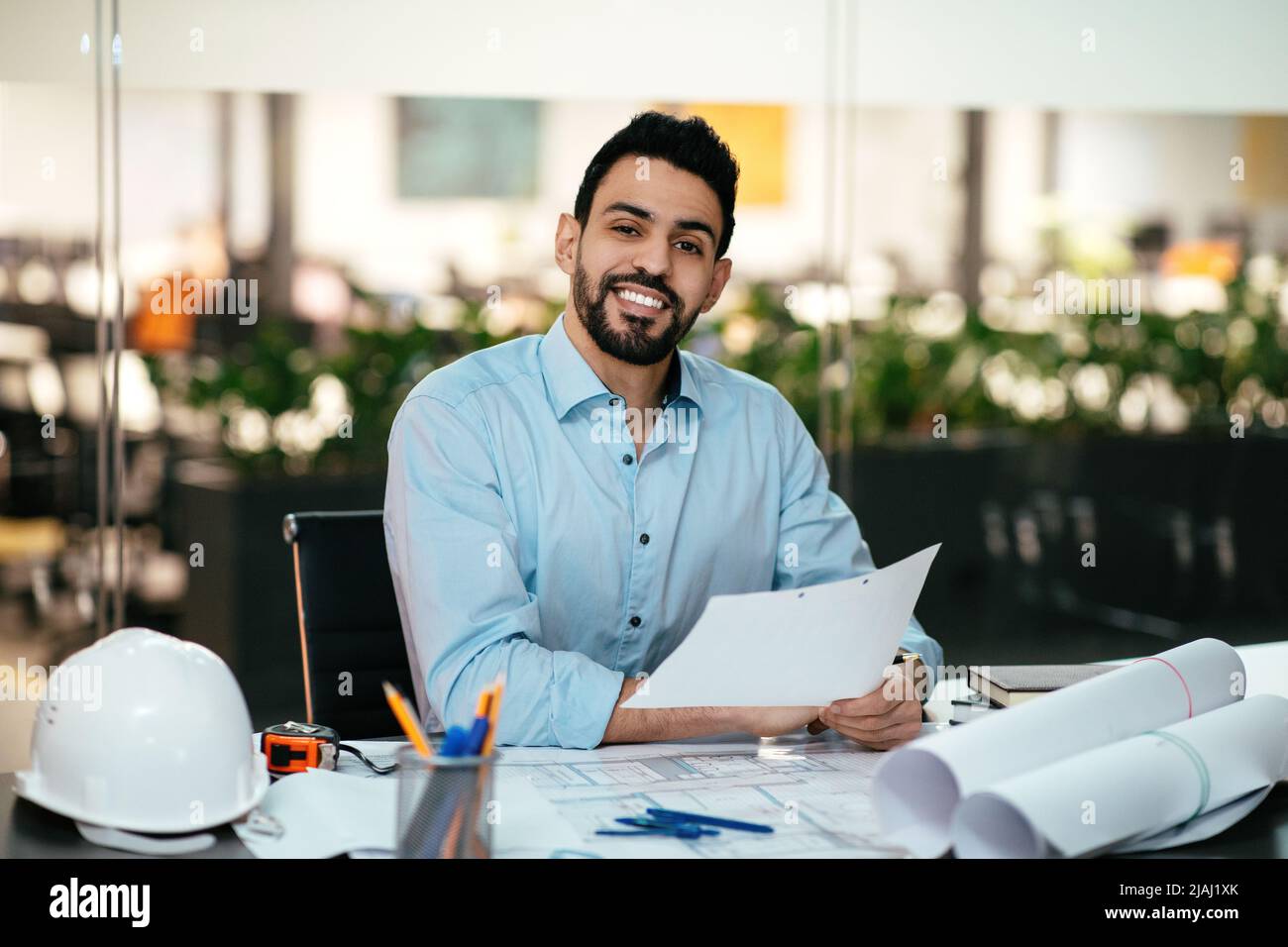 Happy attractive millennial arabic engineer with beard works with ...