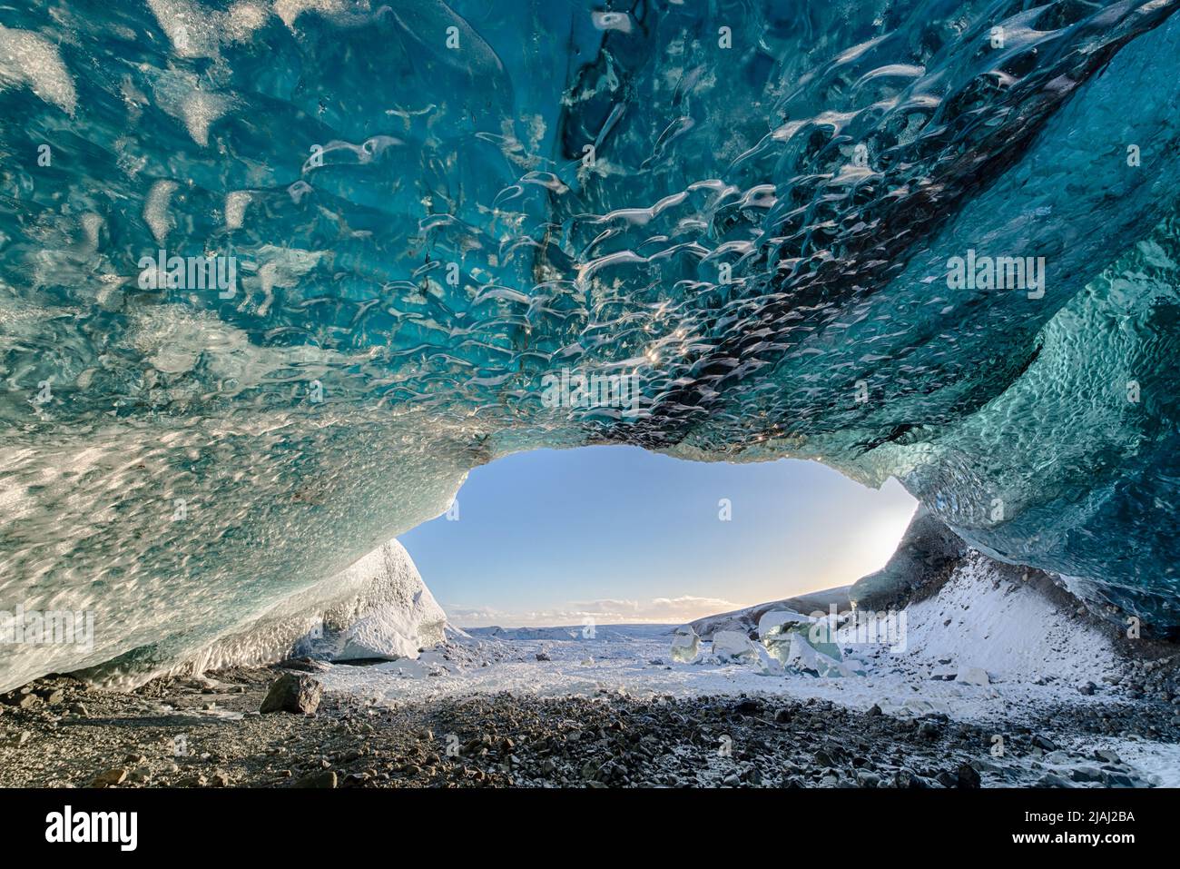 View looking out from inside a deep ice cave underneath a glacier in ...