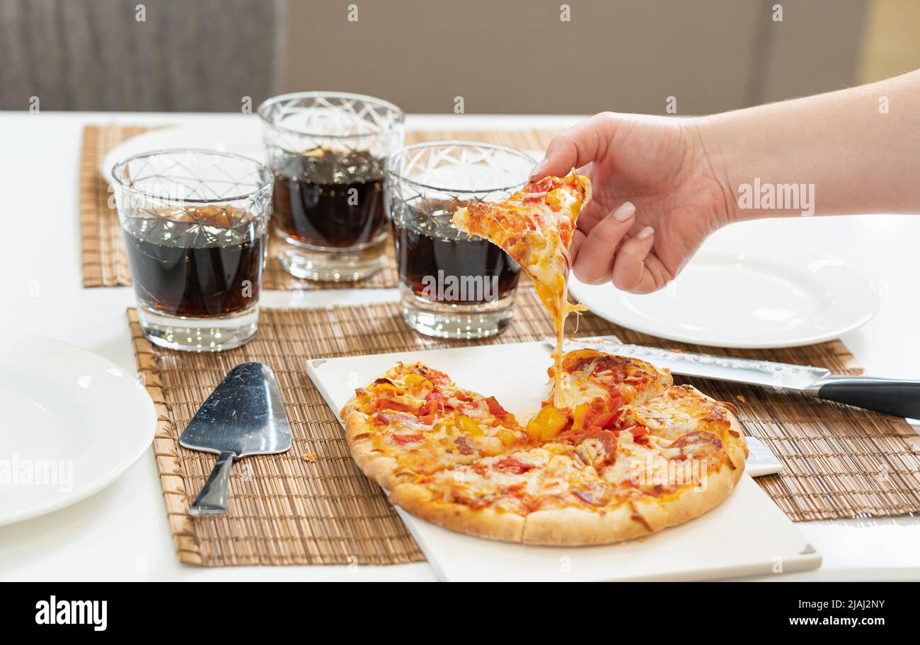 italian homemade pizza and glasses with coca cola on the table evening ...