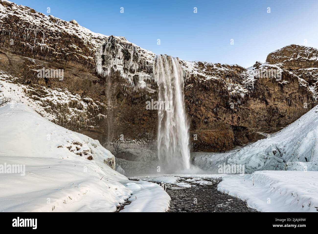 Waterfall in Iceland in Winter surrouned by snow Stock Photo - Alamy