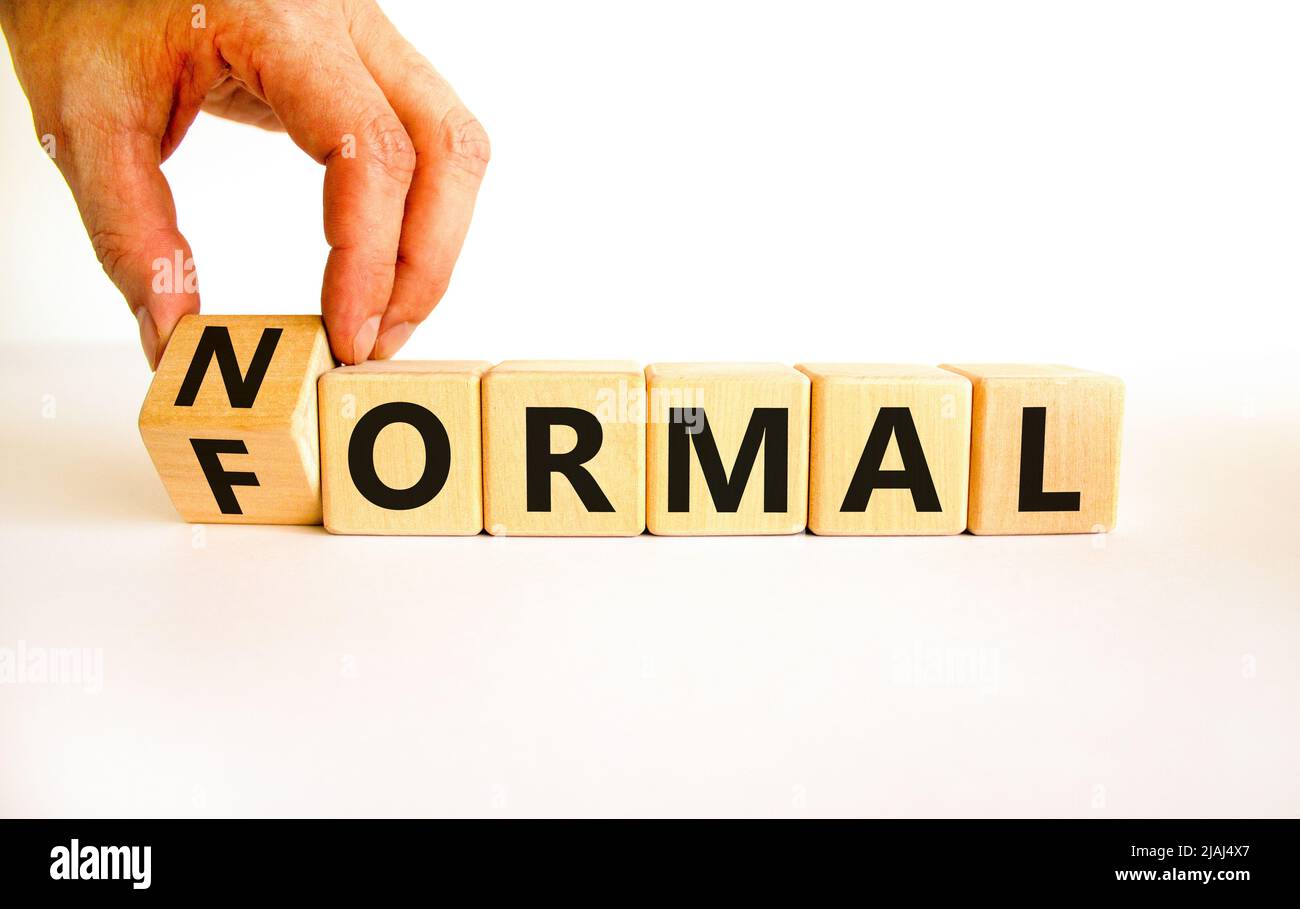 Formal or normal symbol. Businessman turns wooden cubes and changes the ...