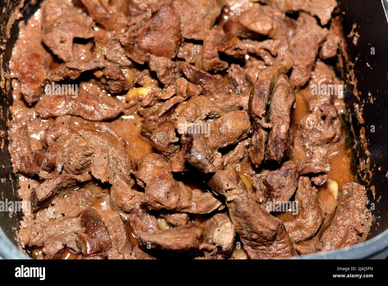 Selective focus of beef liver sliced in pieces and cooked with oil ...