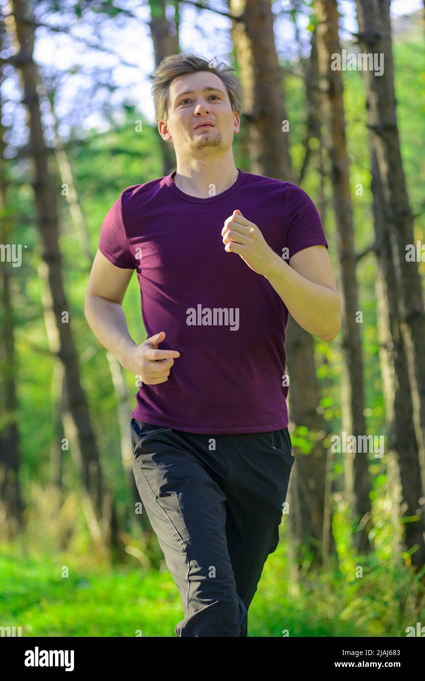 Running man jogging in city park at beautiful summer day. Sport fitness ...
