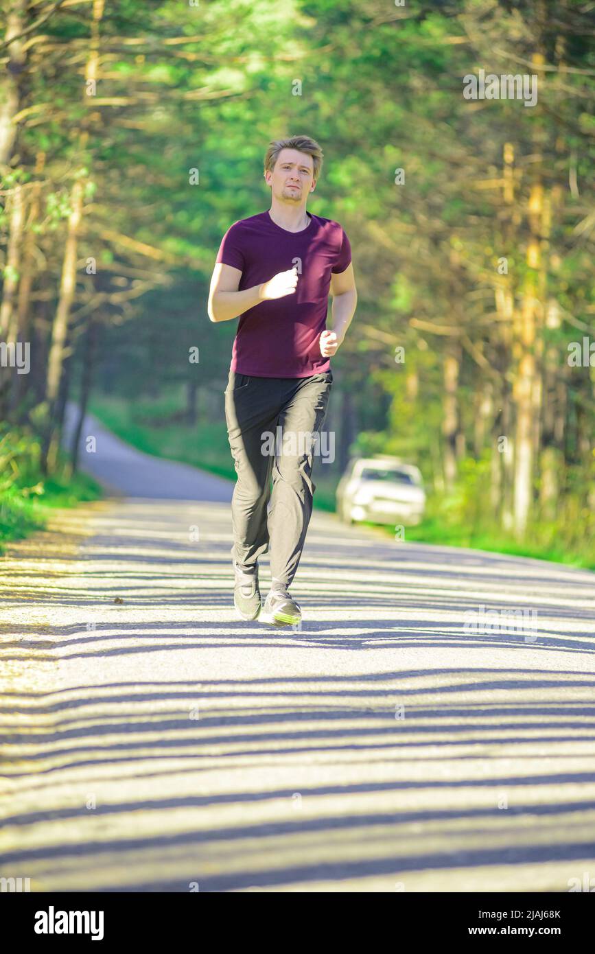 Running man jogging in city park at beautiful summer day. Sport fitness ...