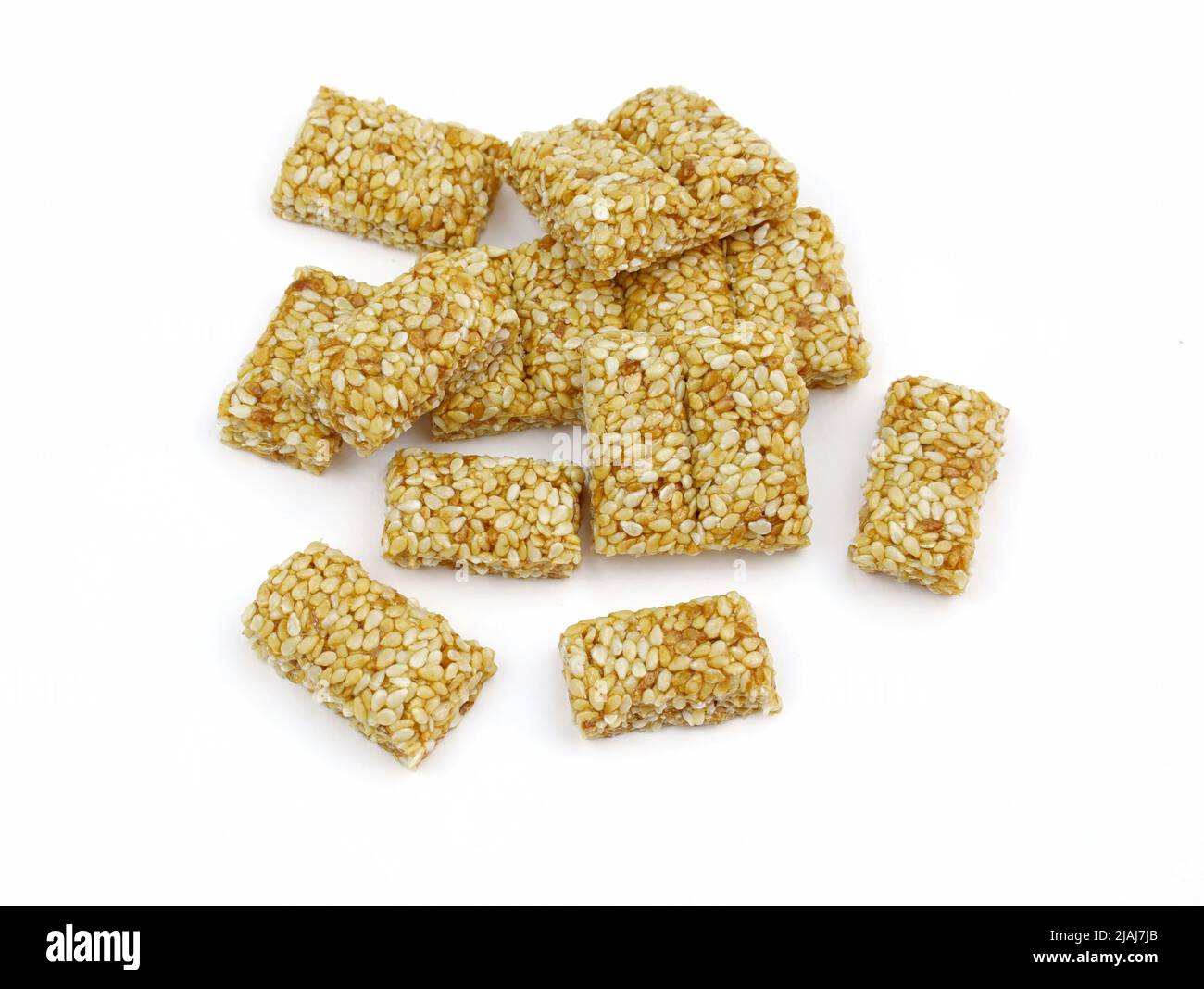 Sesame roasting on a white background. Candy from sesame seeds close-up ...