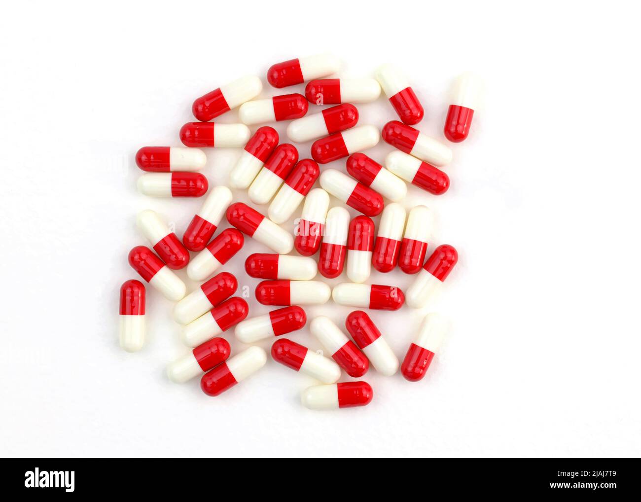 White and red pill capsules on white background. Herbal supplement in ...