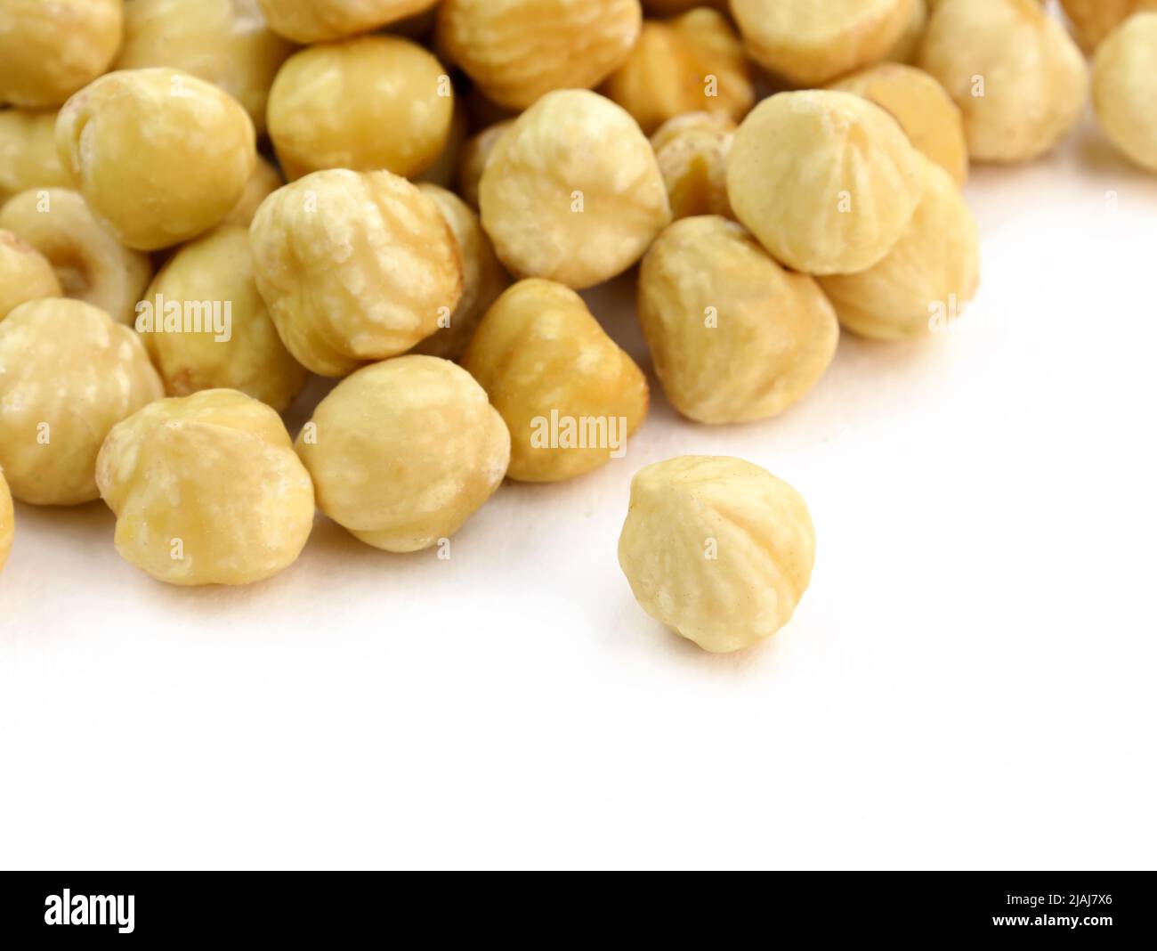 Heap of peeled hazelnuts on a white background close-up. Nuts without ...
