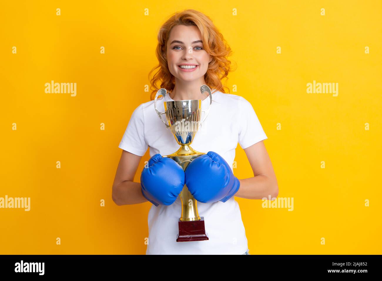 Woman in boxing gloves hold champion winner cup trophy. Winning success ...