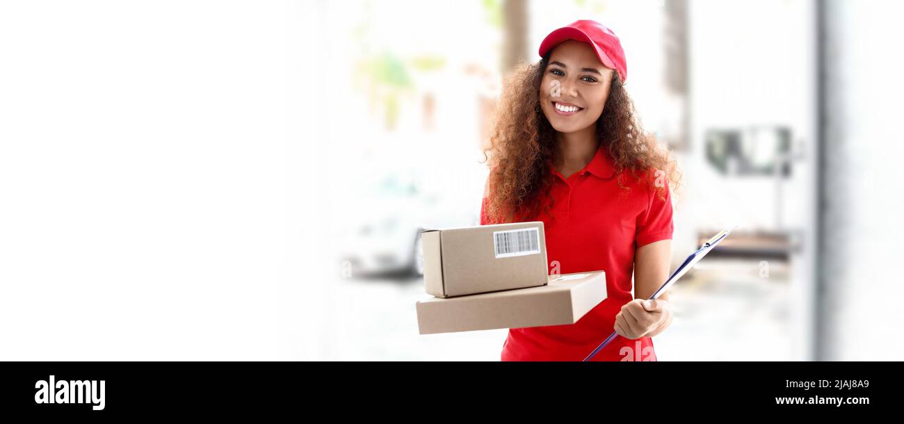African-American female courier with parcels at doorway Stock Photo - Alamy