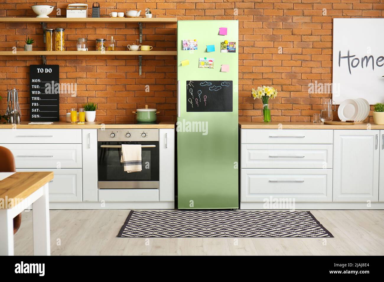 Stylish interior of modern kitchen with big refrigerator near brick ...