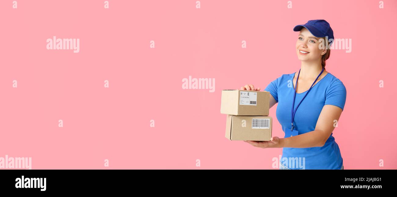 Female courier holding parcels on pink background with space for text ...