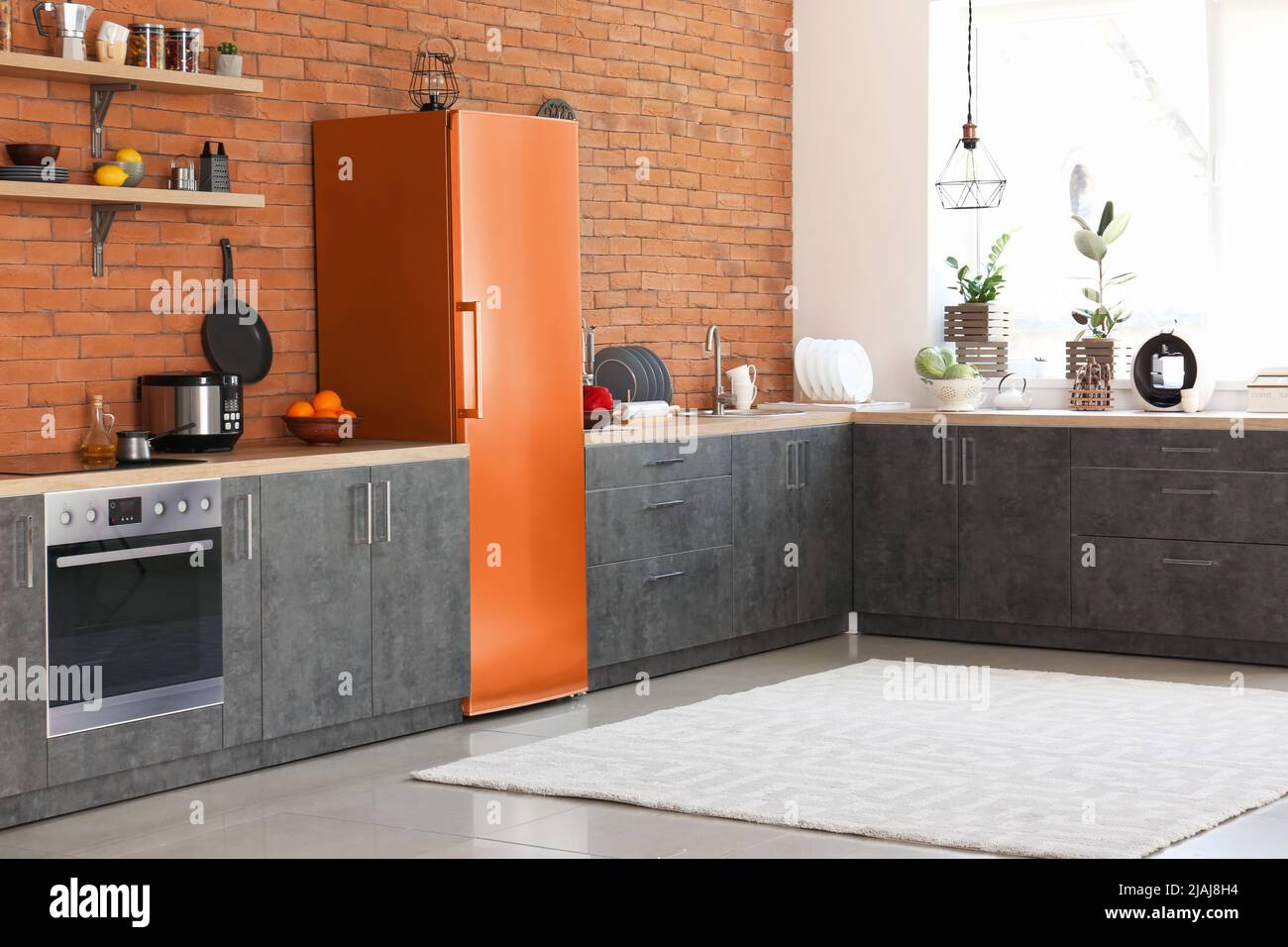 Interior of modern comfortable kitchen with orange fridge Stock Photo ...