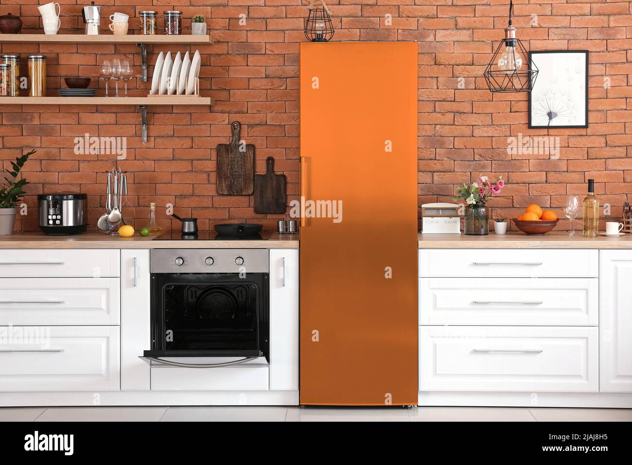 Interior of modern comfortable kitchen with orange fridge and oven near ...