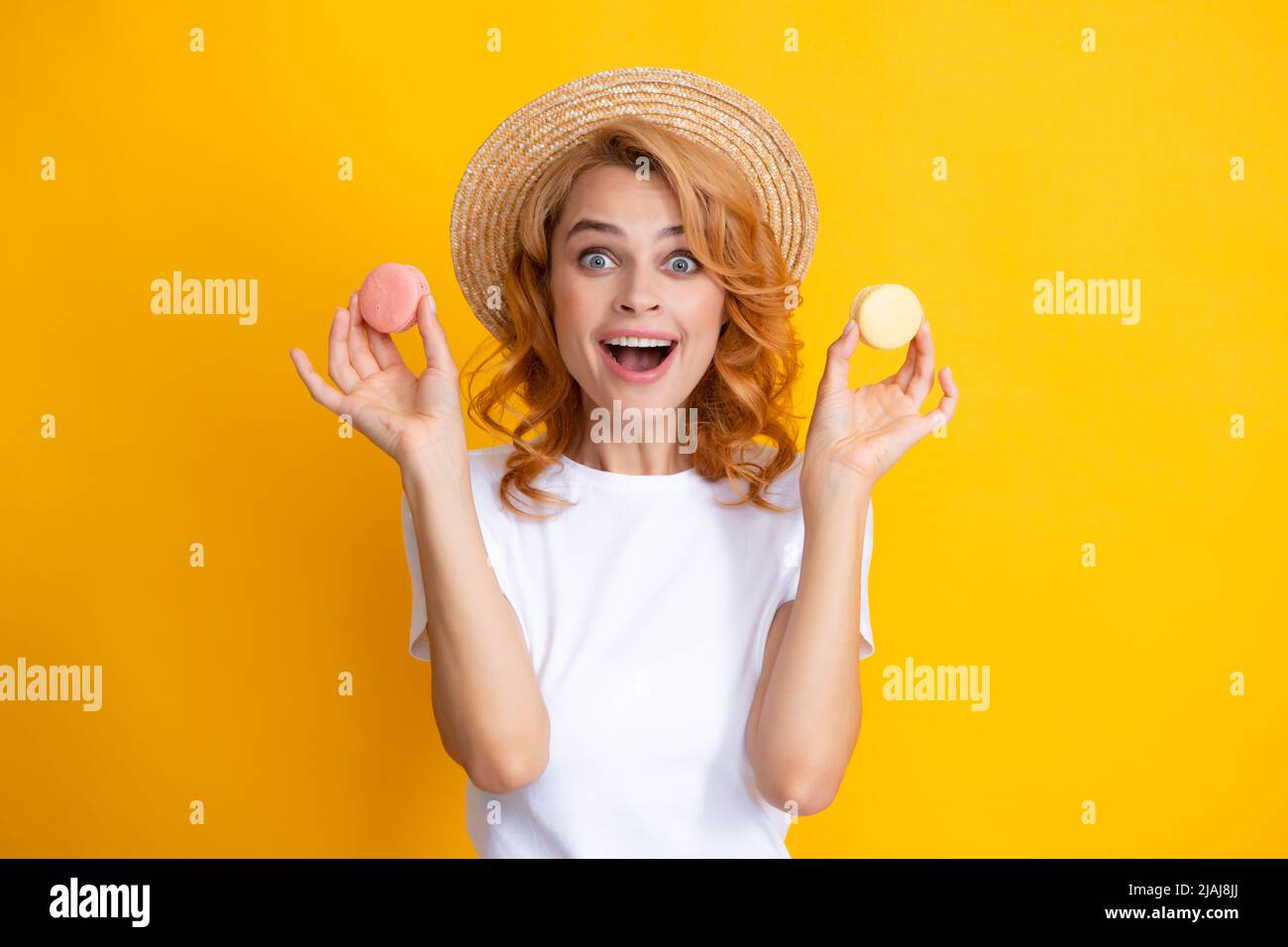 Cute young woman hold macaroon. Beautiful smiling young girl eating ...
