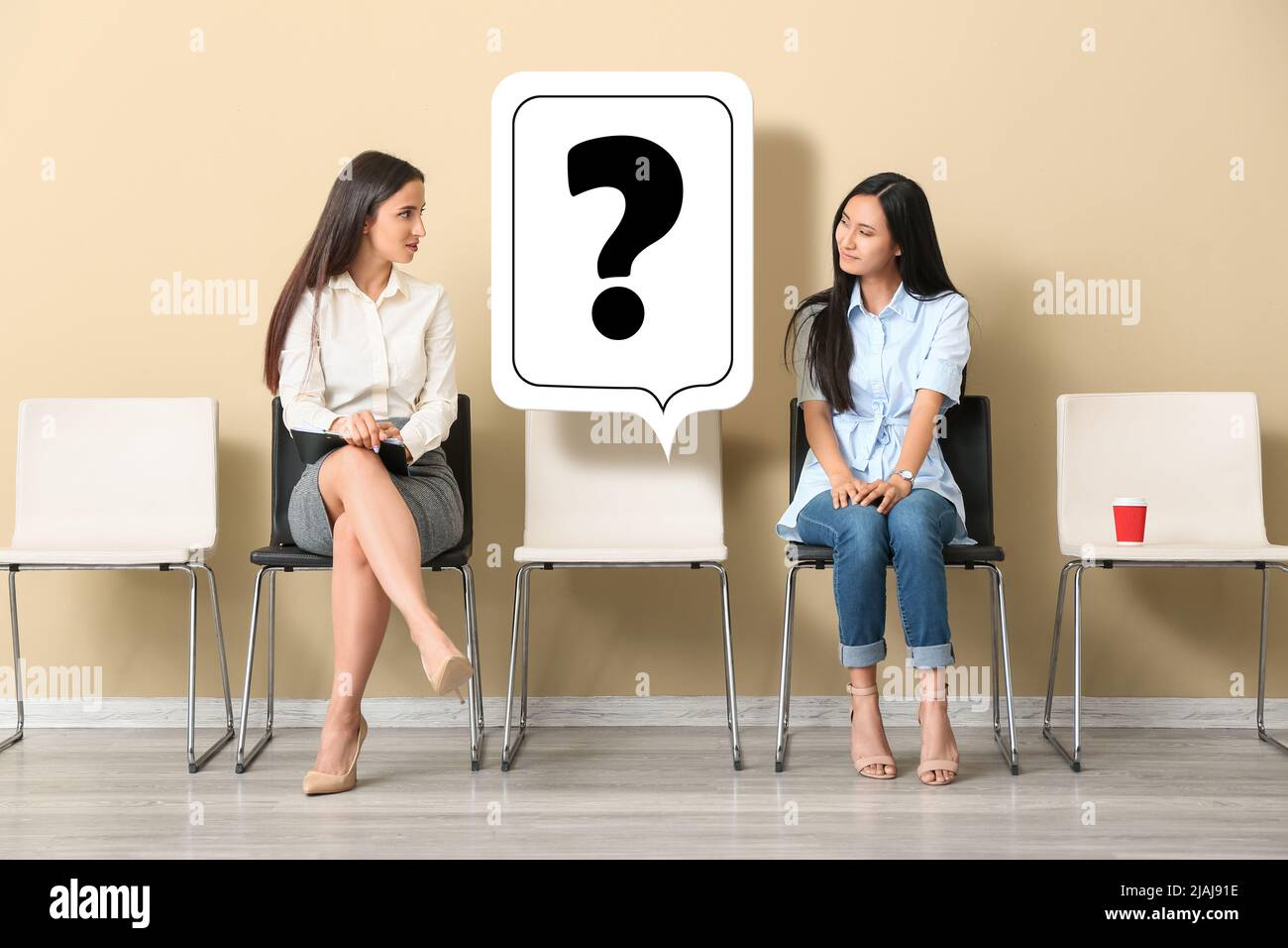 Young women waiting for job interview while sitting on chairs near ...