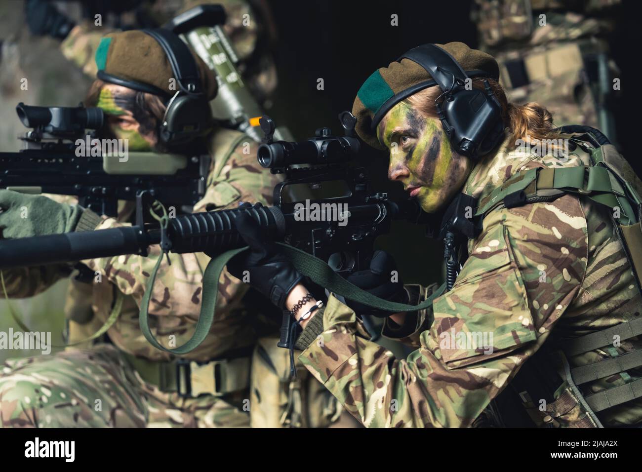 Two soldiers with camouflage painted on their faces aiming at a target ...