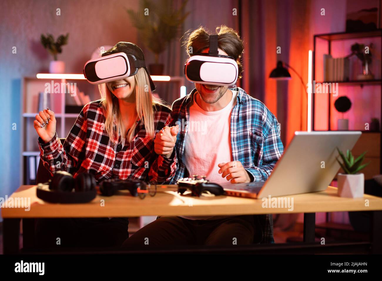 Young pretty woman and handsome man sitting at desk and holding hands ...