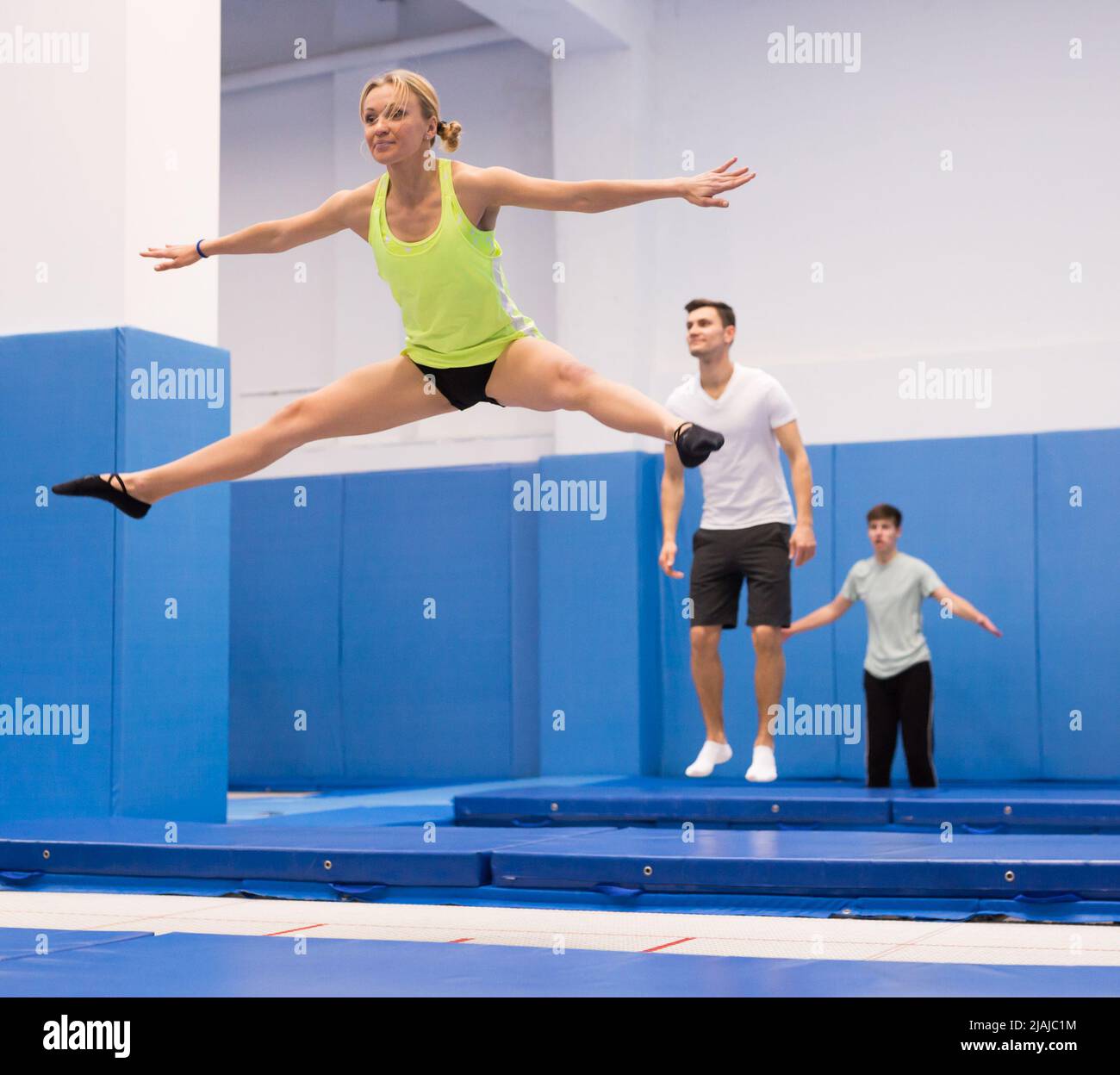 Sports girl training side split on trampoline Stock Photo - Alamy