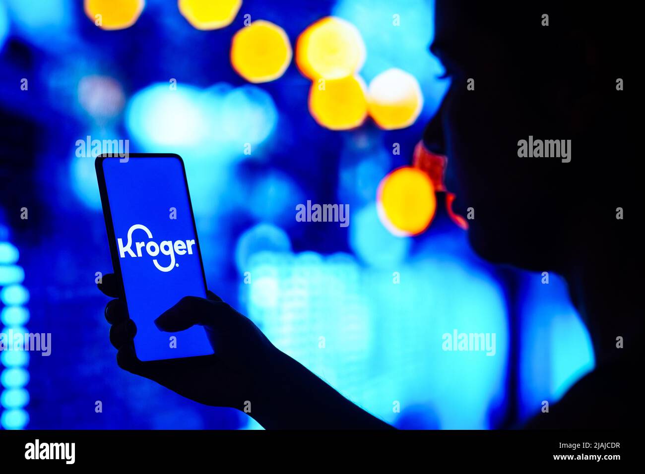 In this photo illustration, a silhouetted woman holds a smartphone with ...