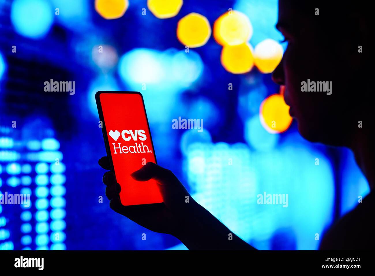 In this photo illustration, a silhouetted woman holds a smartphone with ...