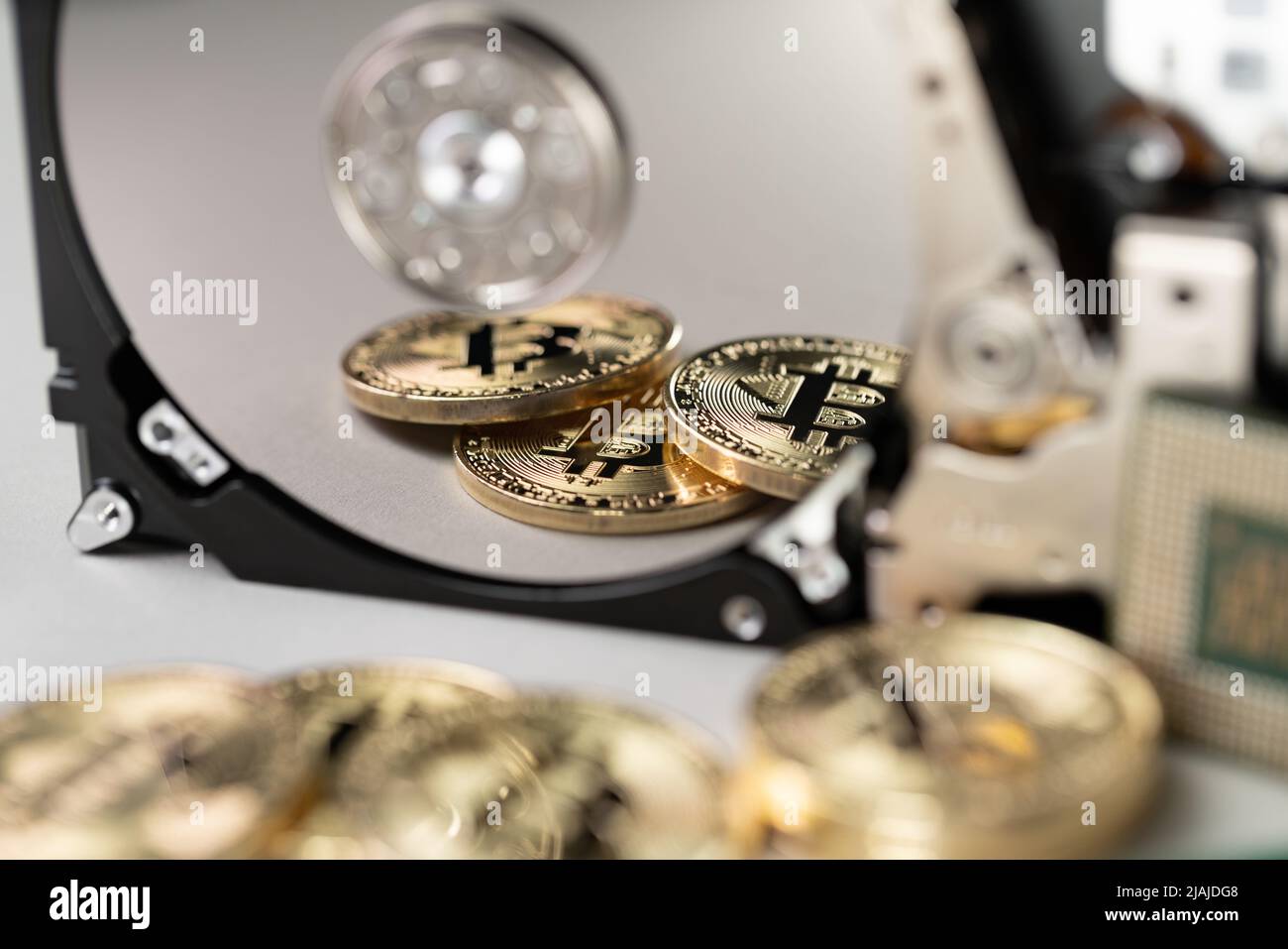 Bitcoin coins reflecting on hard drive disk. Concept of saving ...