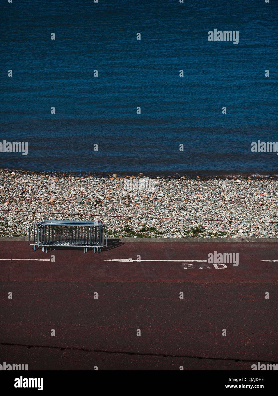 Promenade by pebble beach with road markings and barriers Stock Photo ...