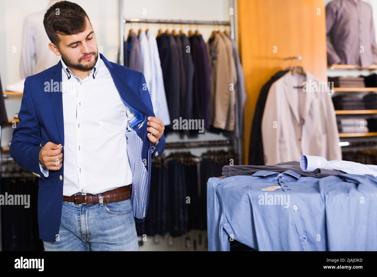 Man customer try new jacket in men clothes shop Stock Photo - Alamy