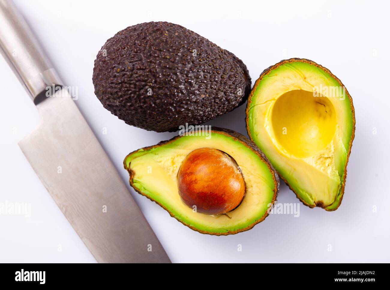 Whole and halved fresh avocados on white background Stock Photo - Alamy