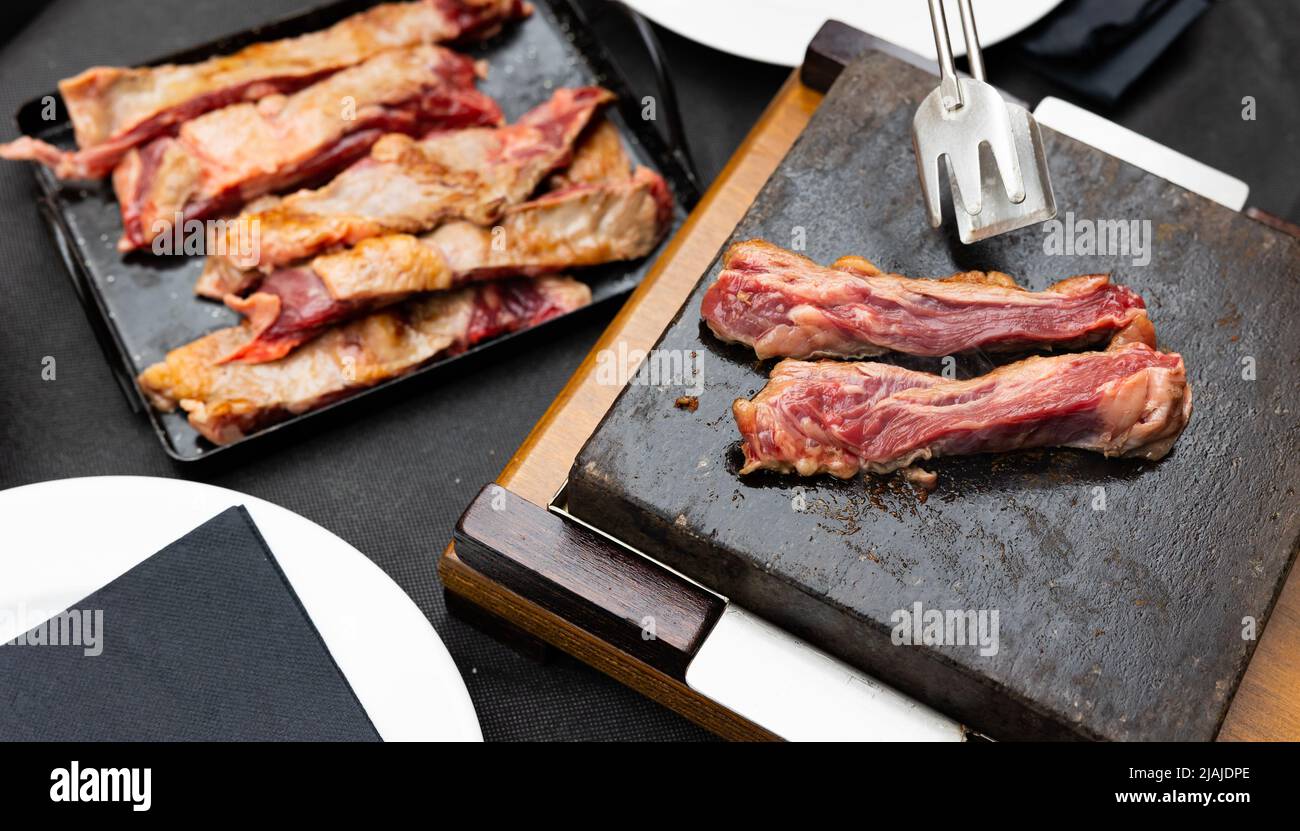 Process of meat cooking on grilling stone Stock Photo - Alamy
