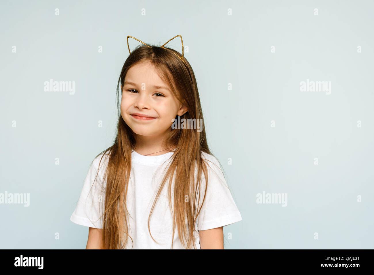 Portrait of young excited smiling girl in cat ears looking at camera on ...