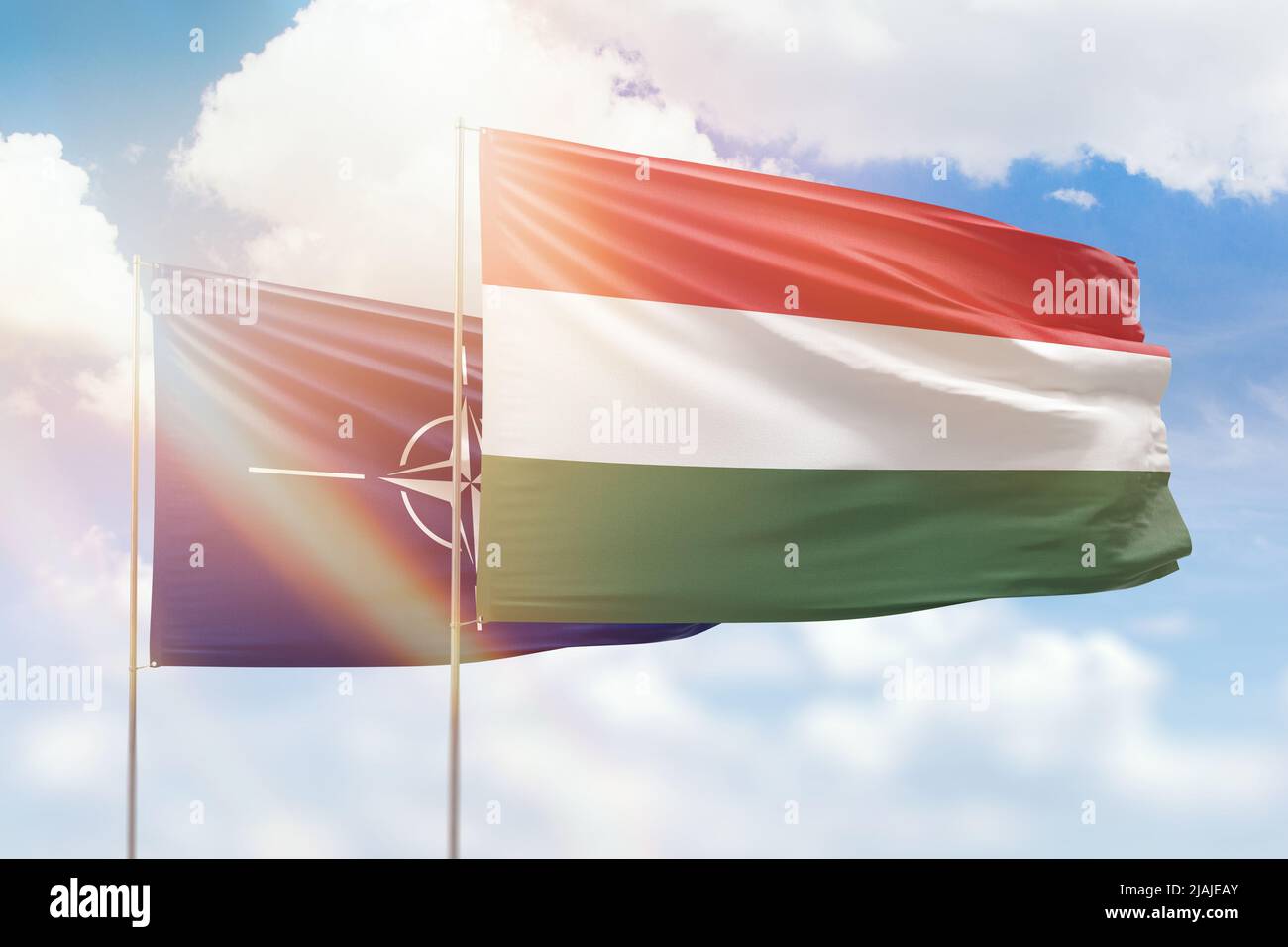 Sunny blue sky and flags of hungary and nato Stock Photo - Alamy