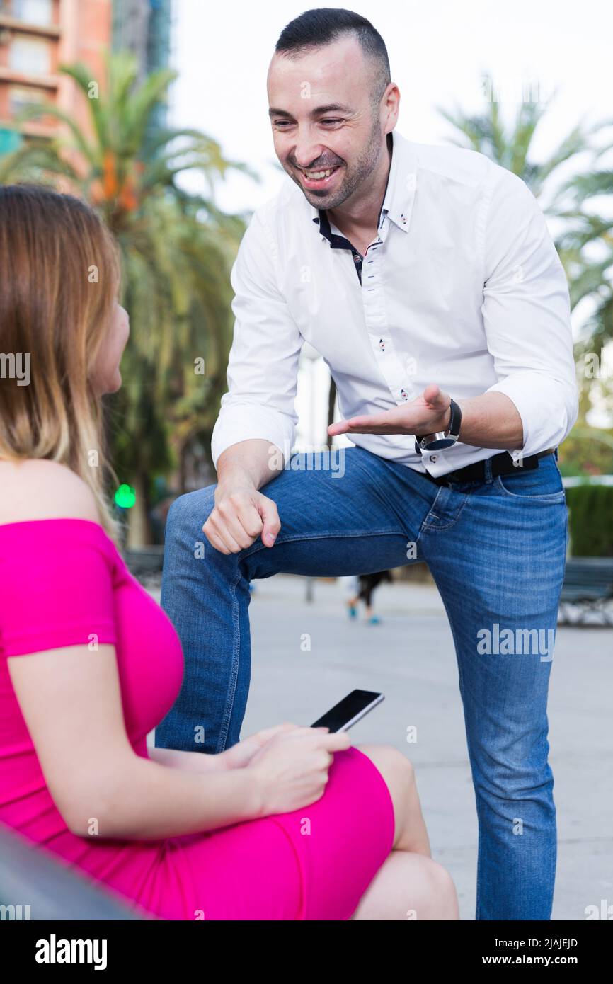 Stranger man is talking with young female who is resting Stock Photo ...