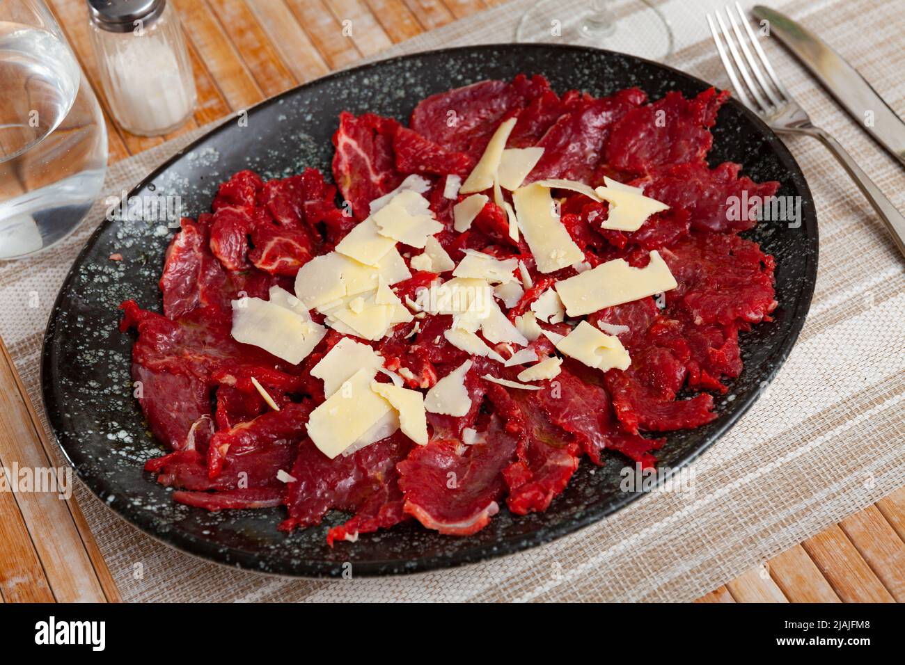 Beef carpaccio with grated cheese served on plate Stock Photo - Alamy