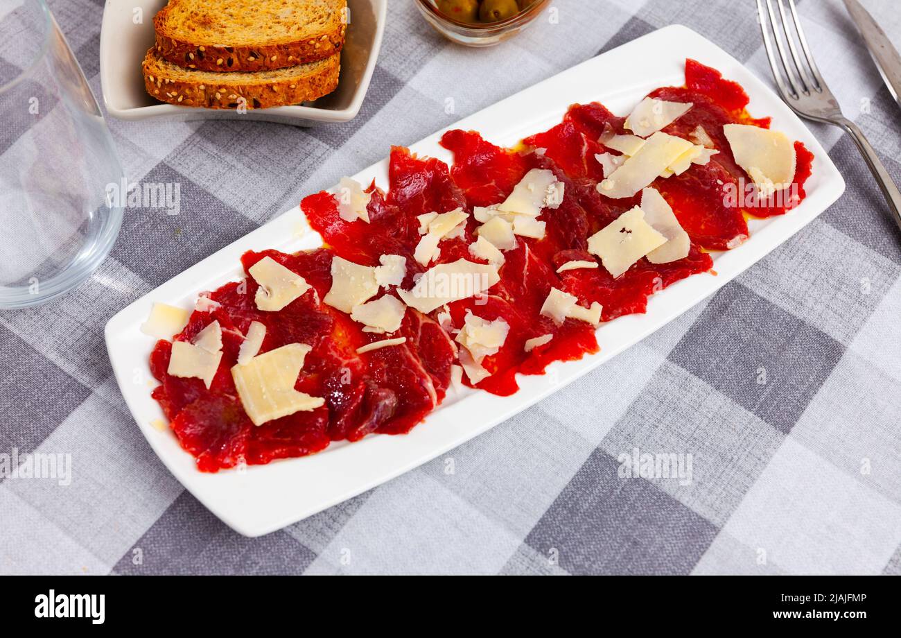 Carpaccio and cheese served on plate Stock Photo - Alamy