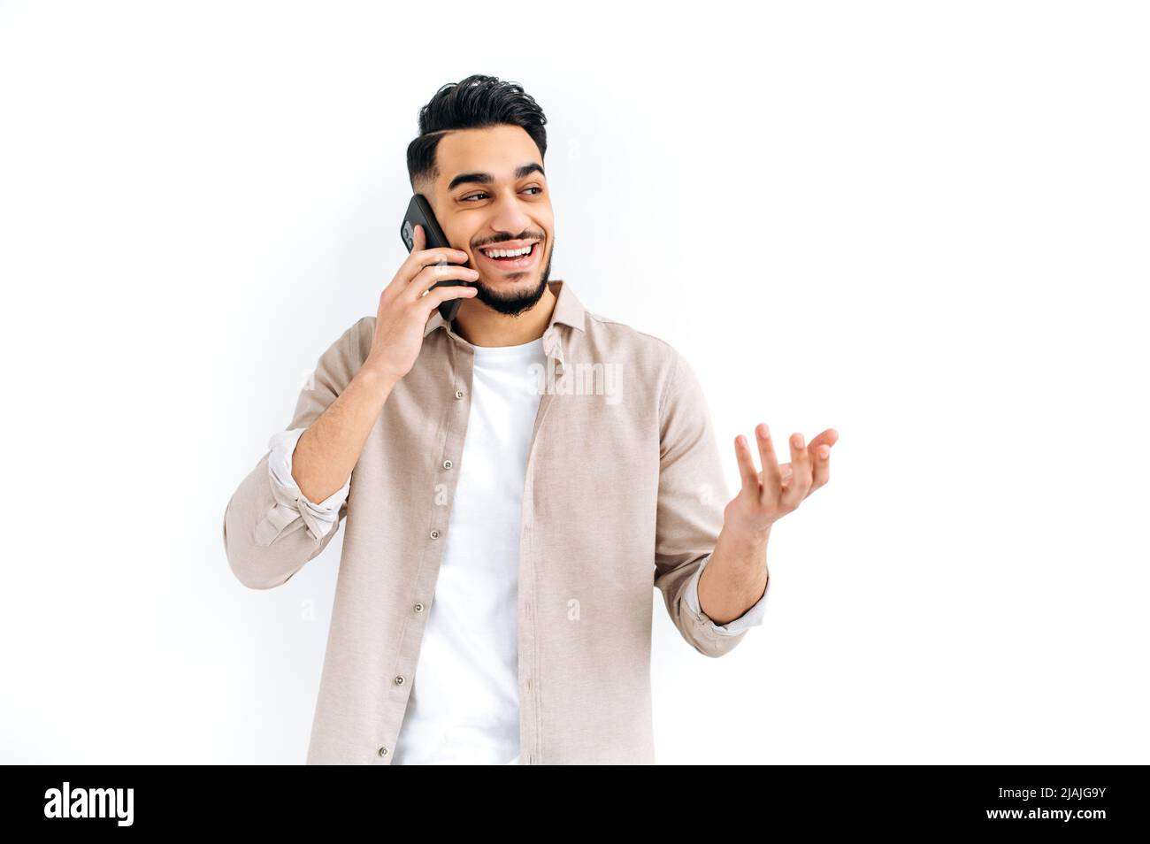 Happy joyful excited Indian or arabian charismatic guy has a pleasant ...