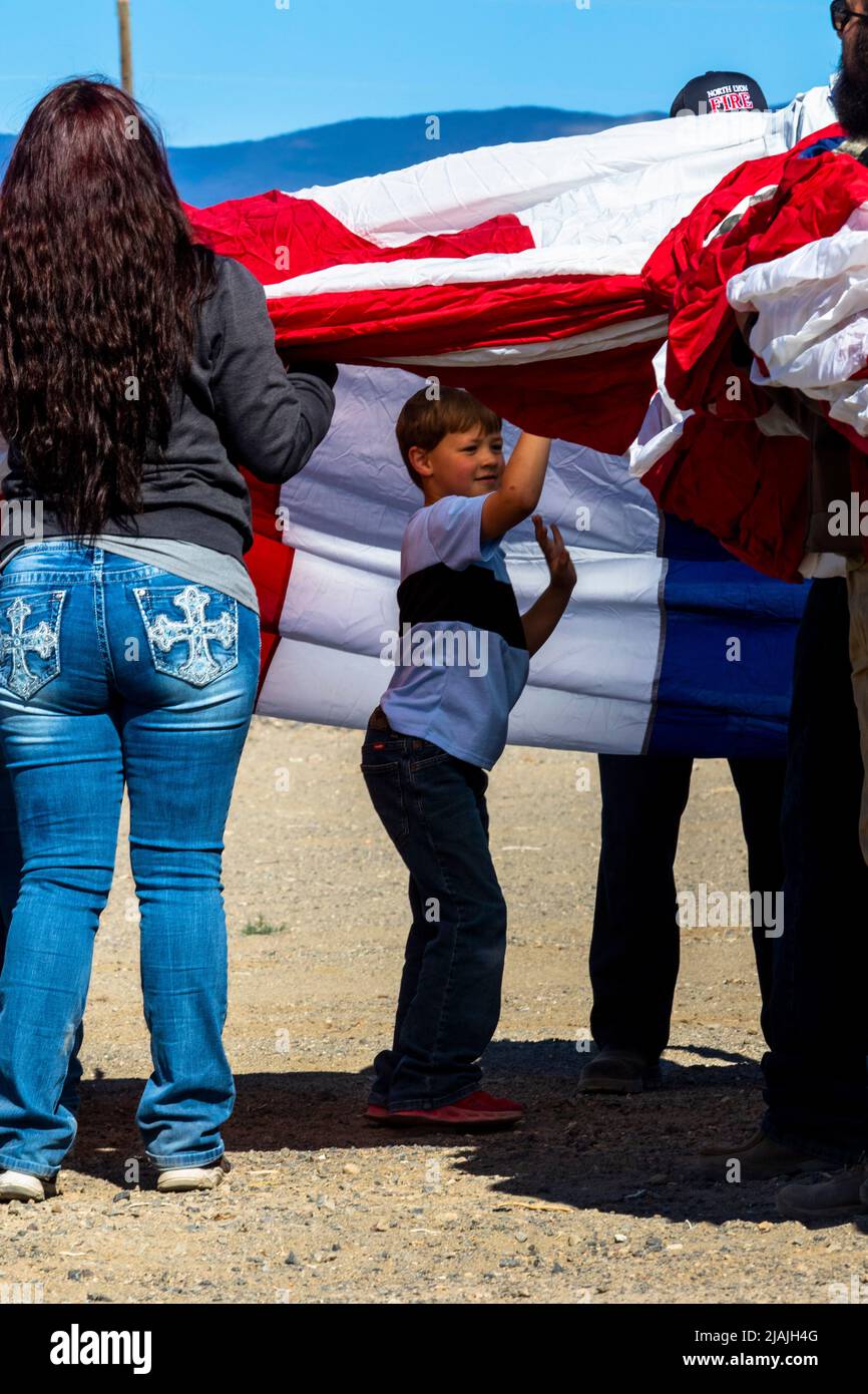 A child plays under an American flag. People attended a Memorial day ...