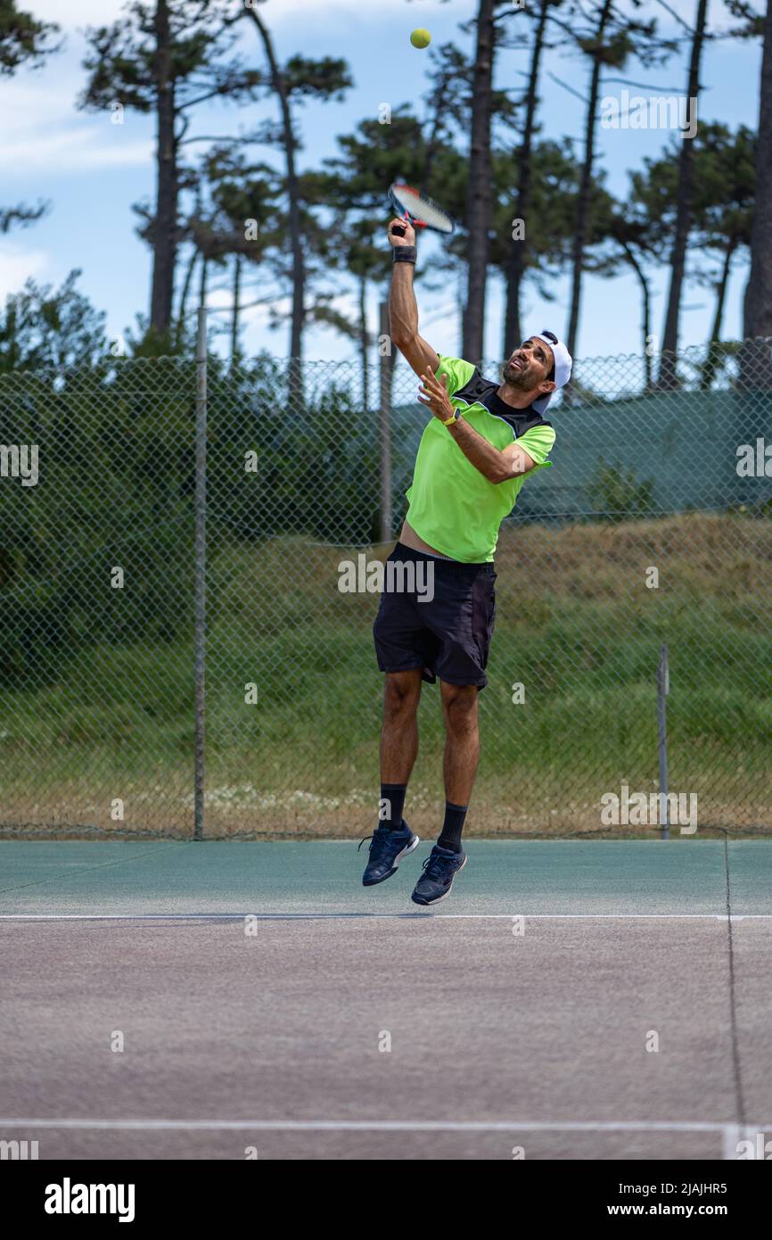 Tennis player performing a service on court Stock Photo - Alamy