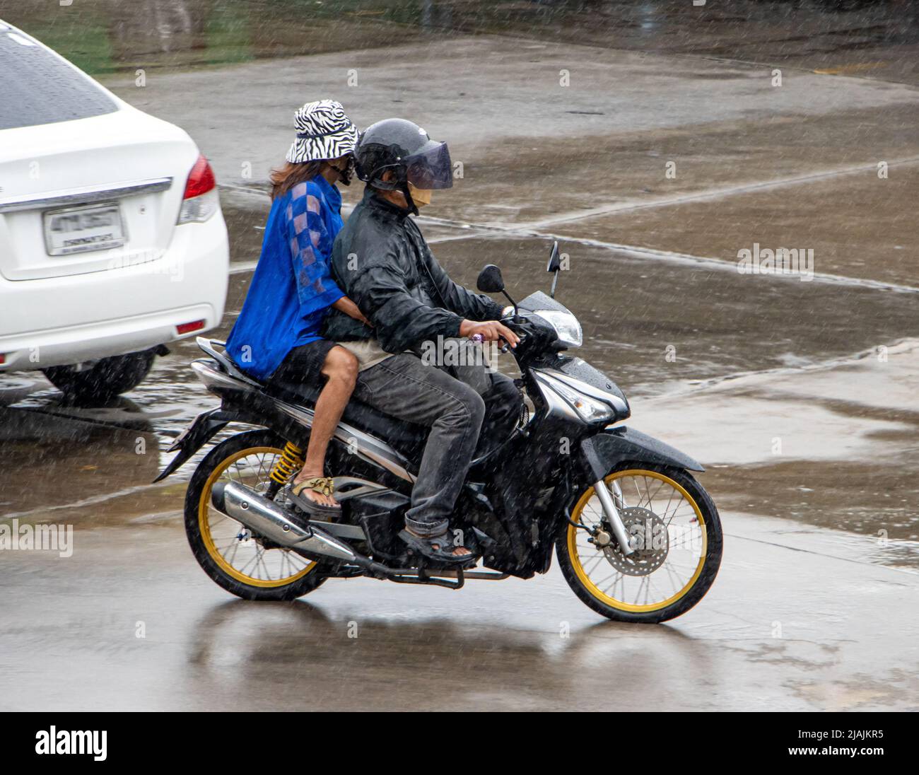 A couple rides a motorcycle in the rain Stock Photo - Alamy