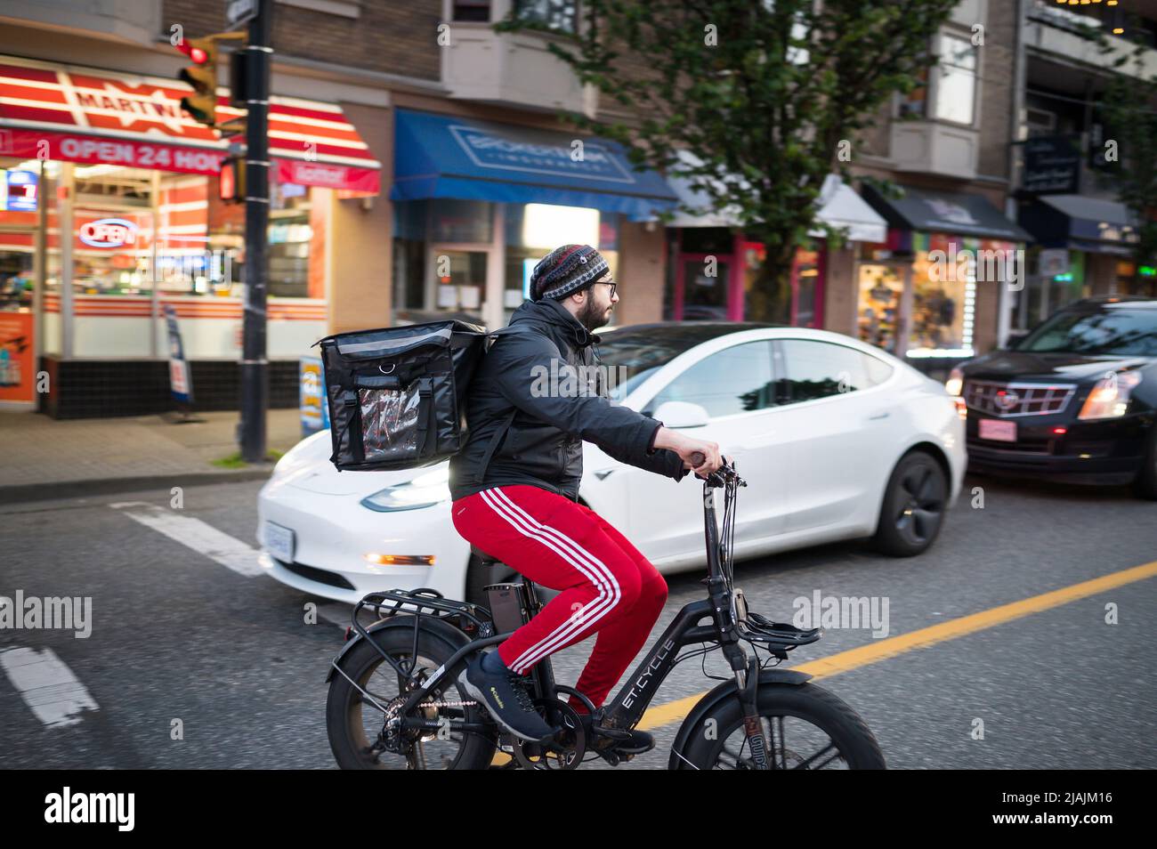 Food delivery riders on electric bikes ride through VancouverÕs West ...