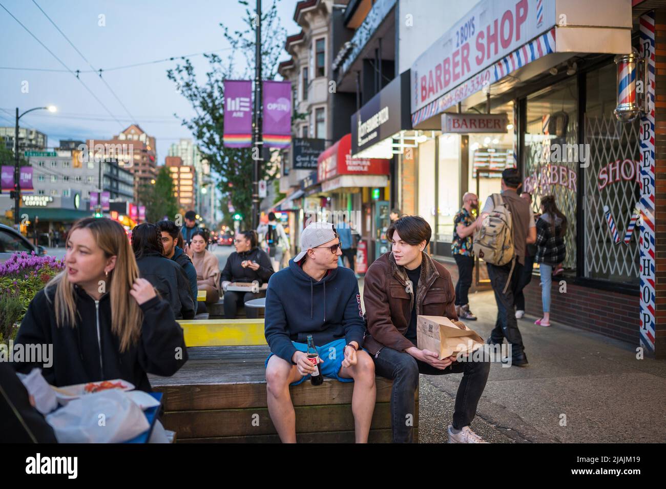 People eat take out meals at an on-street outdoor dining area in ...