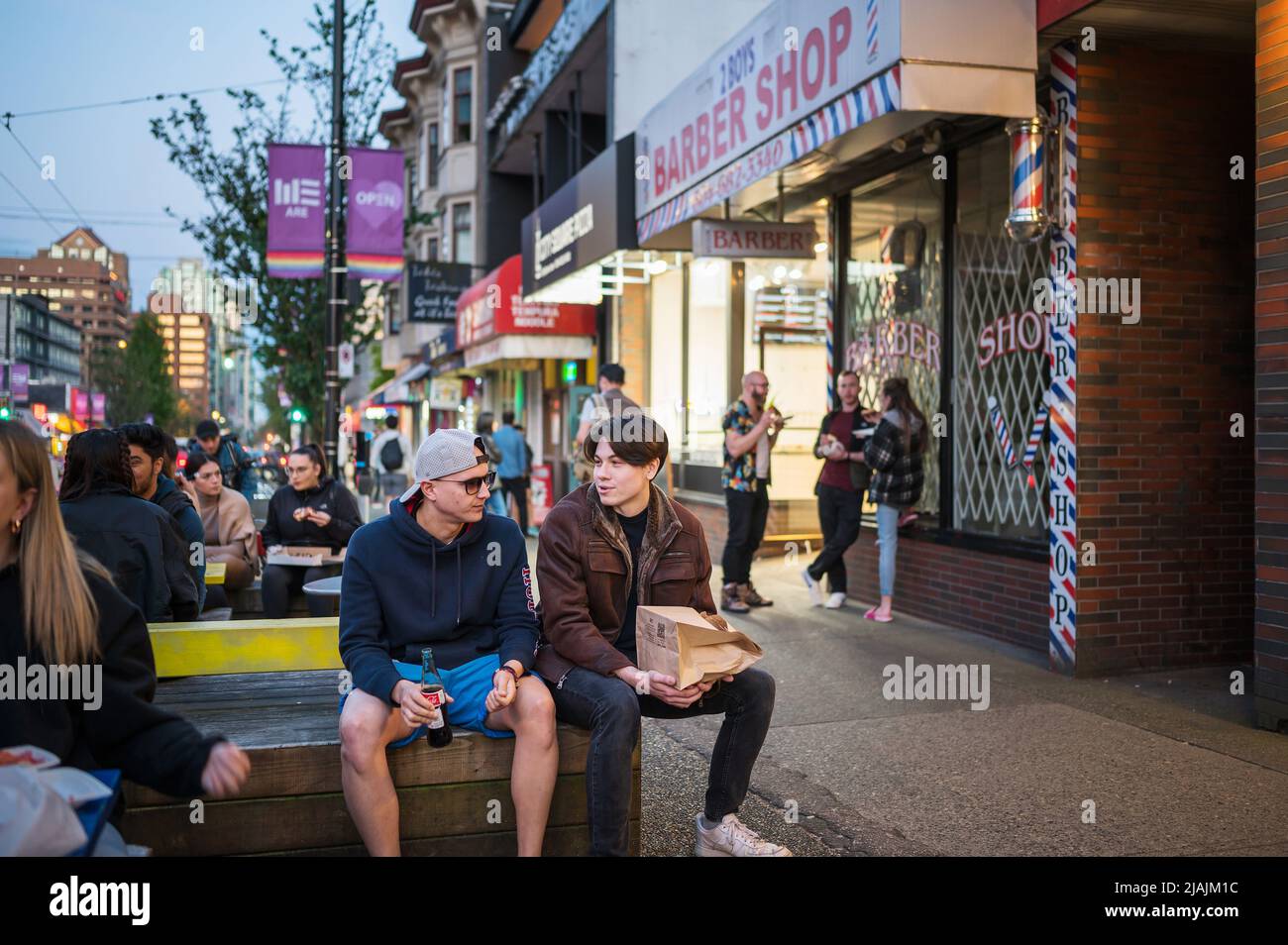 People eat take out meals at an on-street outdoor dining area in ...